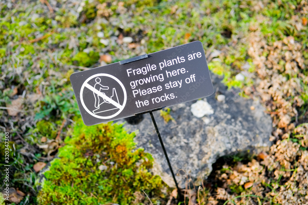 Improvised sign warning people to keep off a delicate garden rockery ...
