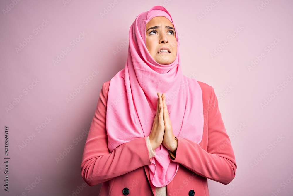Young beautiful girl wearing muslim hijab standing over isolated pink ...
