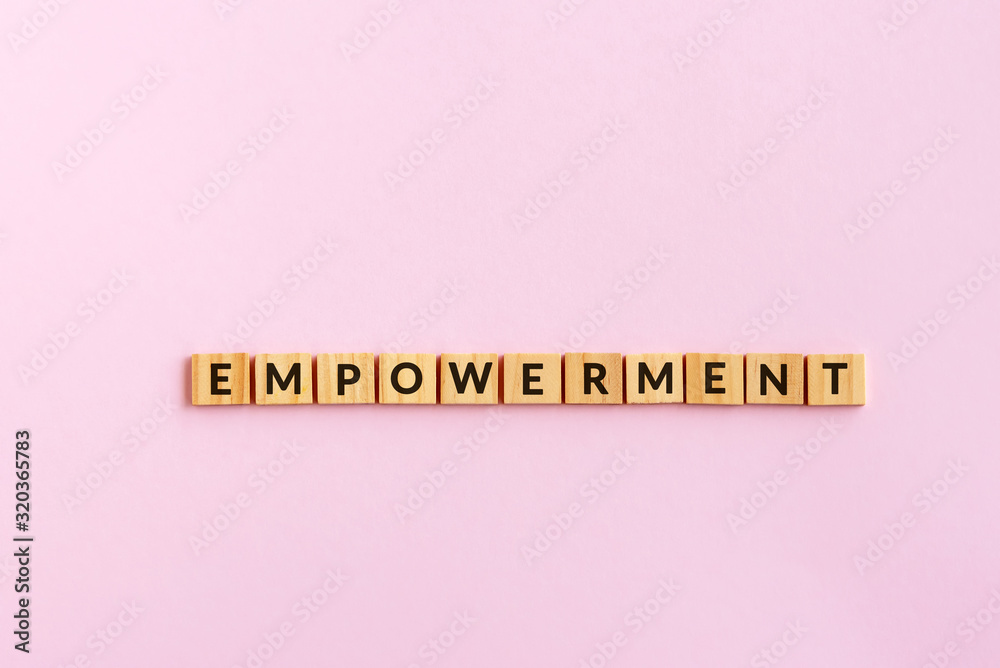 Empowerment text wood blocks. Pink background. Stock Photo | Adobe Stock