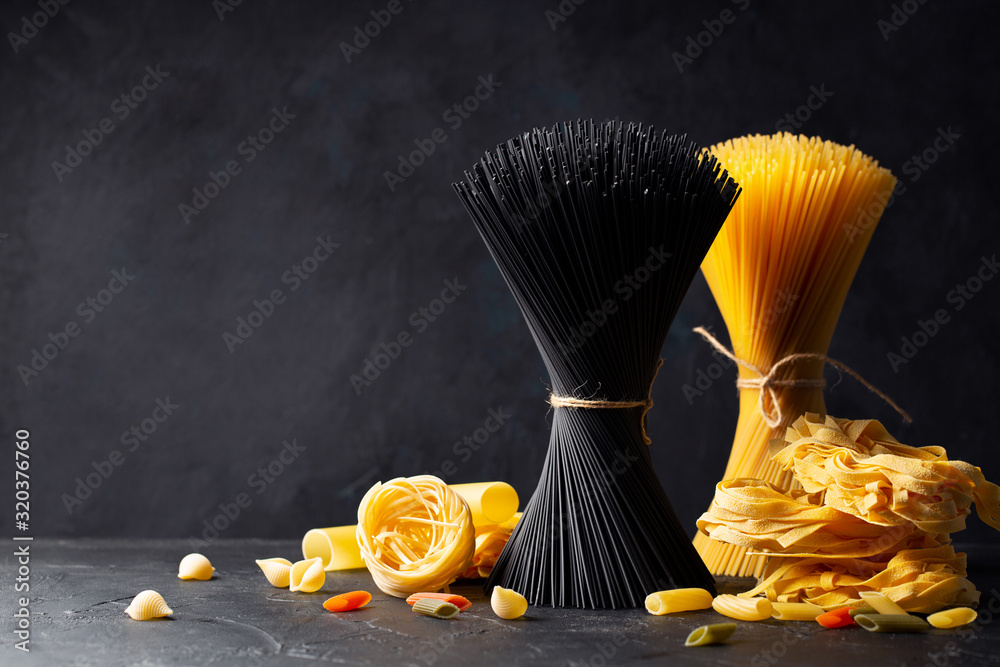 Variety of types and shapes of Italian dry pasta on black background ...
