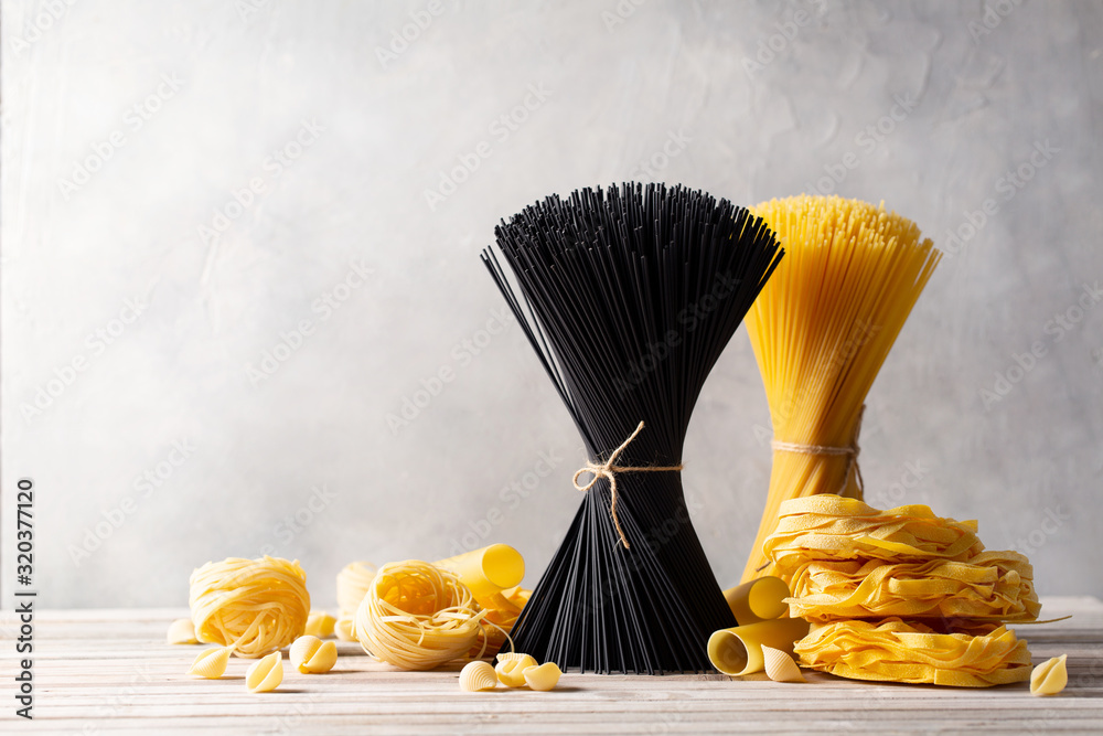 Variety of types and shapes of Italian dry pasta on grey background ...