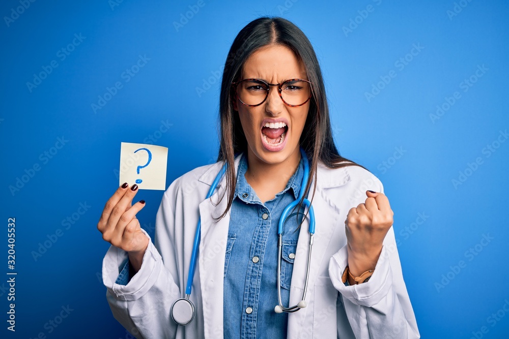 Young beautiful brunette doctor woman holding paper with question mark ...