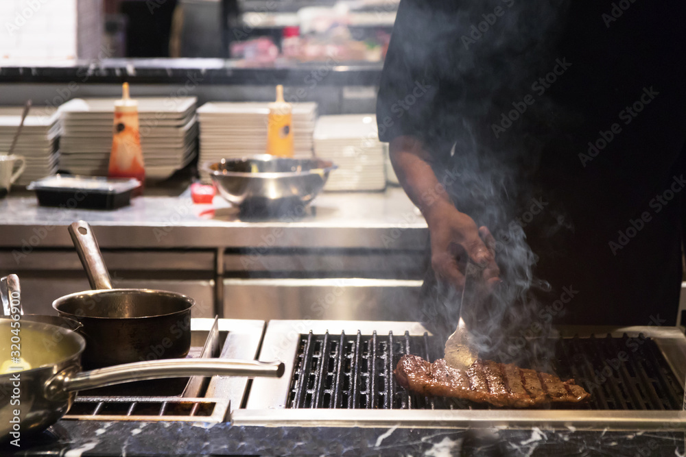 Chef cooking in a open kitchen; customer can see they cooking at food ...