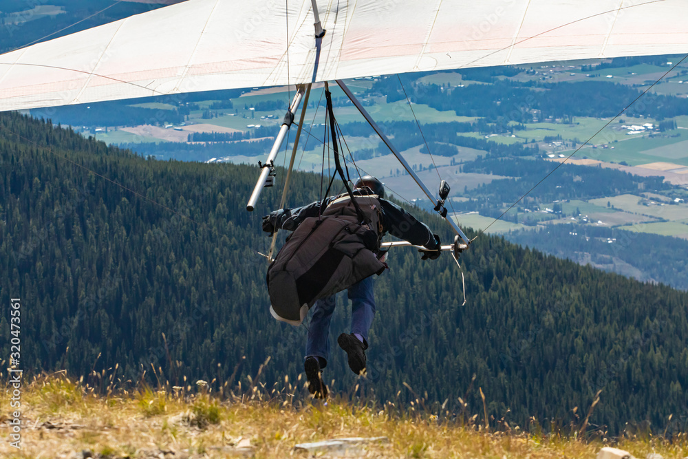 Professional Hang glider man running and taking off. View from the Back ...