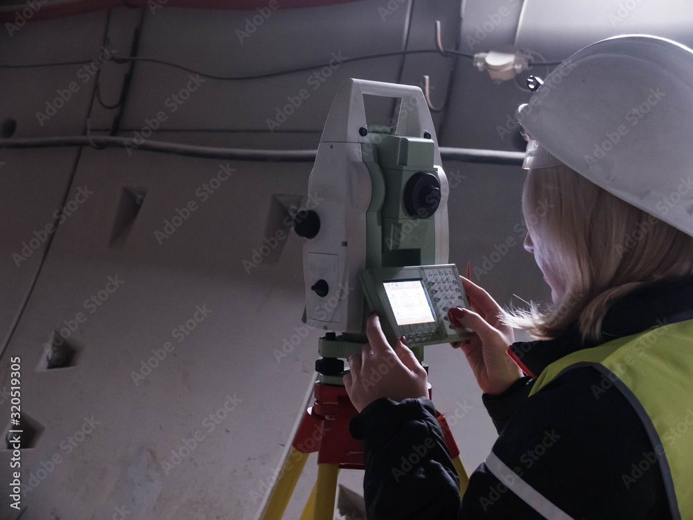Portrait of pretty young mining surveyor woman in hardhat standing by ...