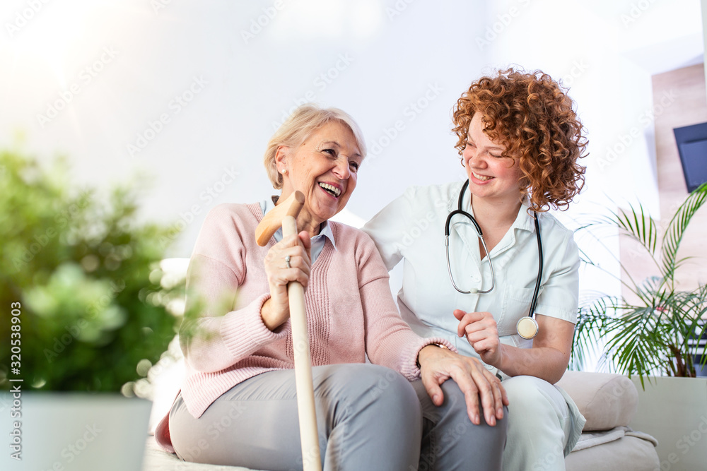 Friendly relationship between smiling caregiver in uniform and happy ...
