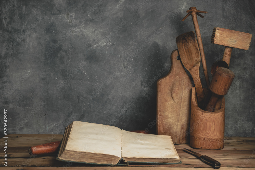 Beautiful vintage cookbook with kitchen utensils on a oak wooden table ...