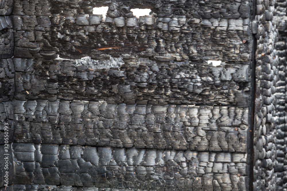 Charred boards in a vertical position. The inner wall of a wooden ...