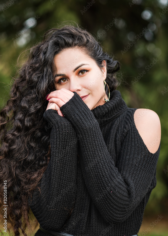 belle jeune brune aux cheveux longs et frisés en extérieur devant un ...
