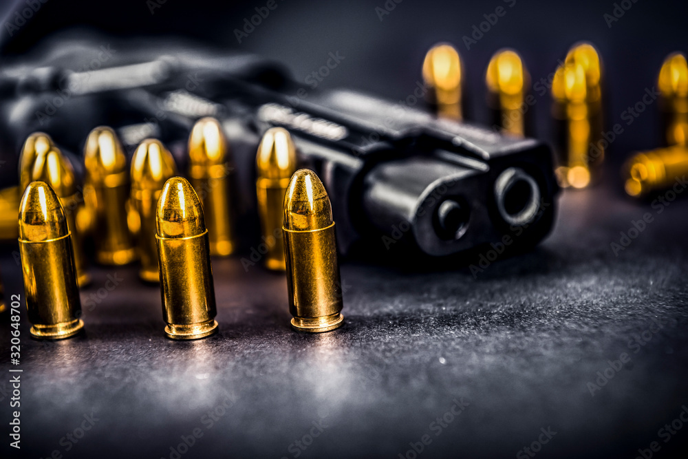 Bullets and handcuffs. Close-up of 9mm pistol. Gun and weapon with ...