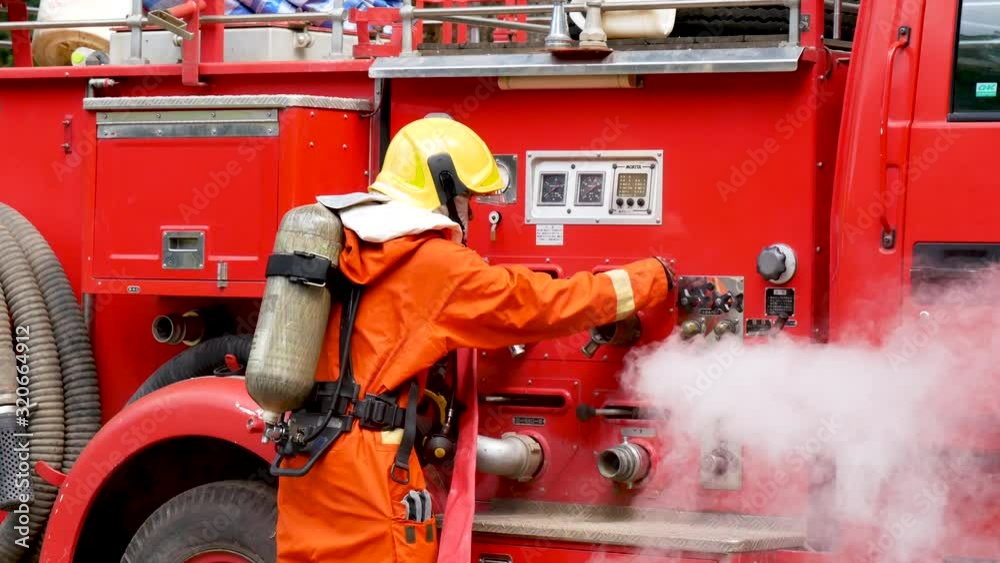 Firefighter fighting with fire flame protection property. Fireman wear ...