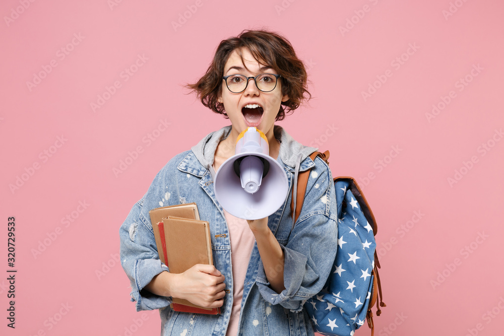 Funny young woman student in denim clothes, eyeglasses, backpack posing ...
