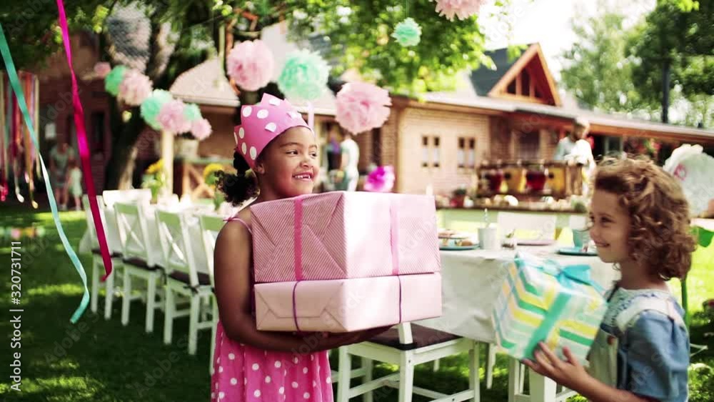 A birthday party of small girl outdoors in garden in summer ...