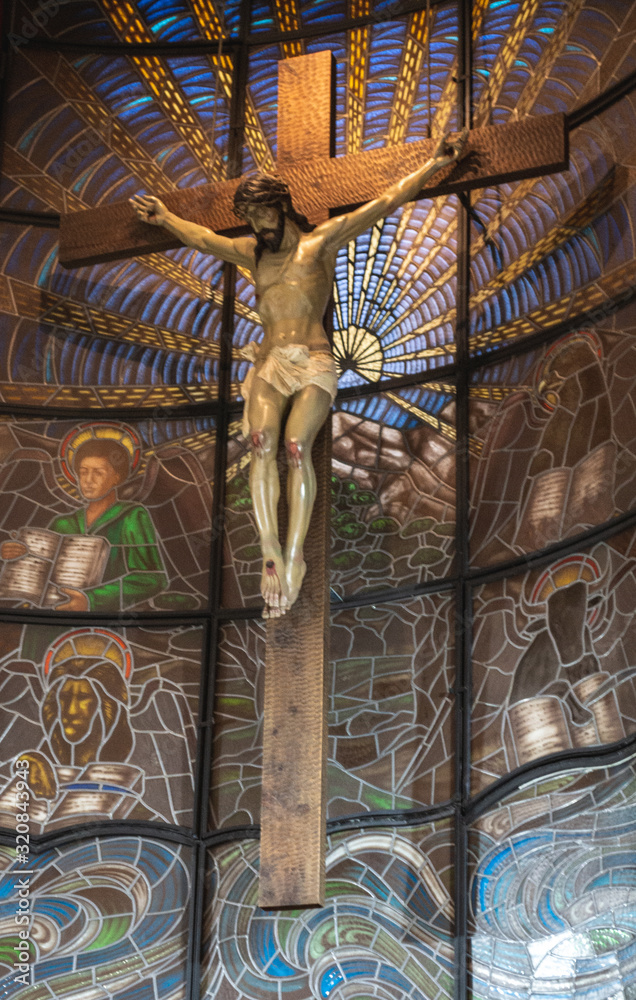 statue of jesus christ on the cross in front of stained glass windows ...