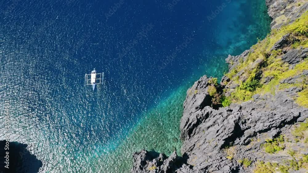 Aerial top down view of boat moving in open sea with clear and ...