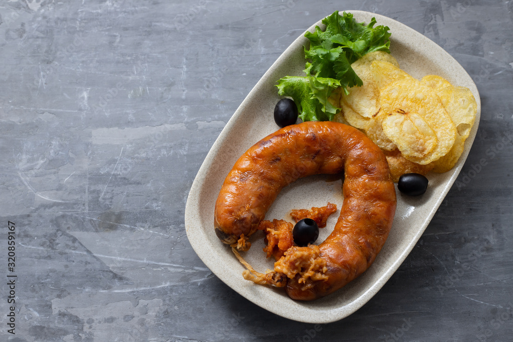 typical portuguese smoked sausage alheira with potato chips and fresh ...