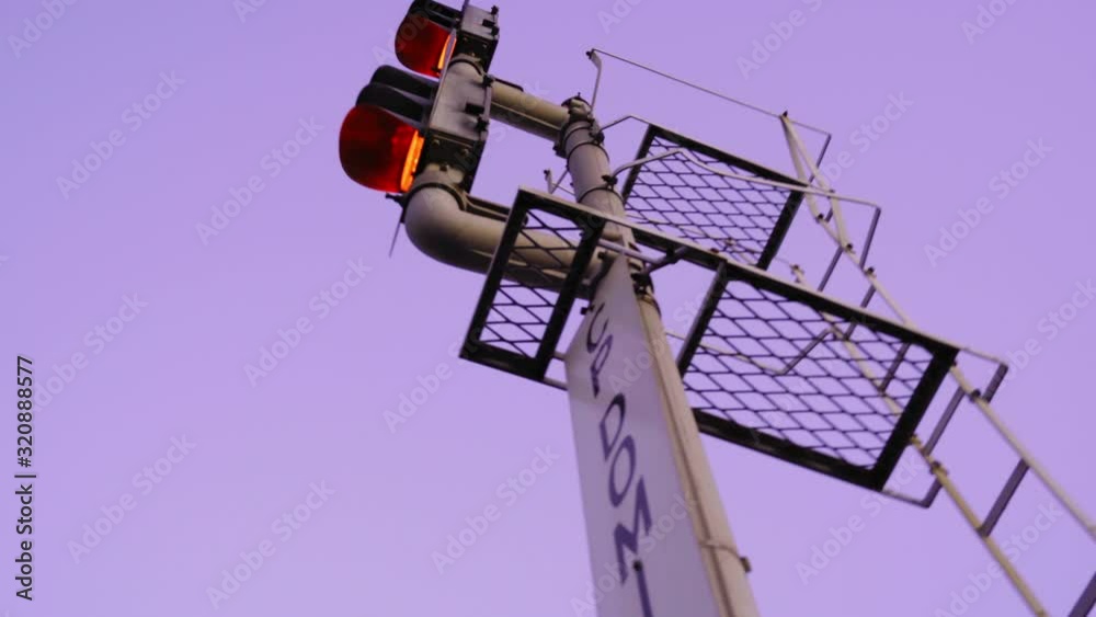 Rotating around a railroad signal traffic light with a beautiful purple ...