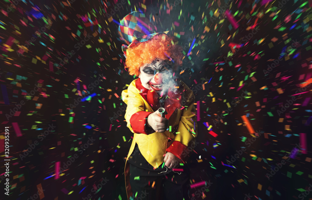 Evil scary clown explodes a party Popper standing on a black background ...