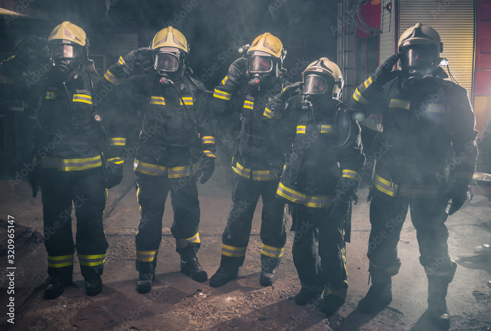Team of fireman standing the middle of the fire extinguisher's smoke ...