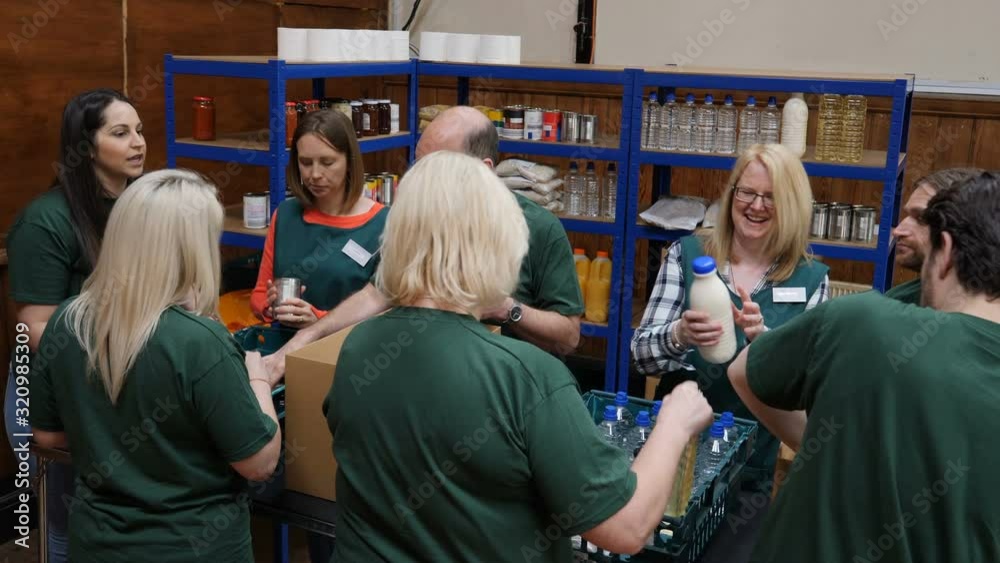 Group of Food Bank volunteers help to sort tinned food for people in ...