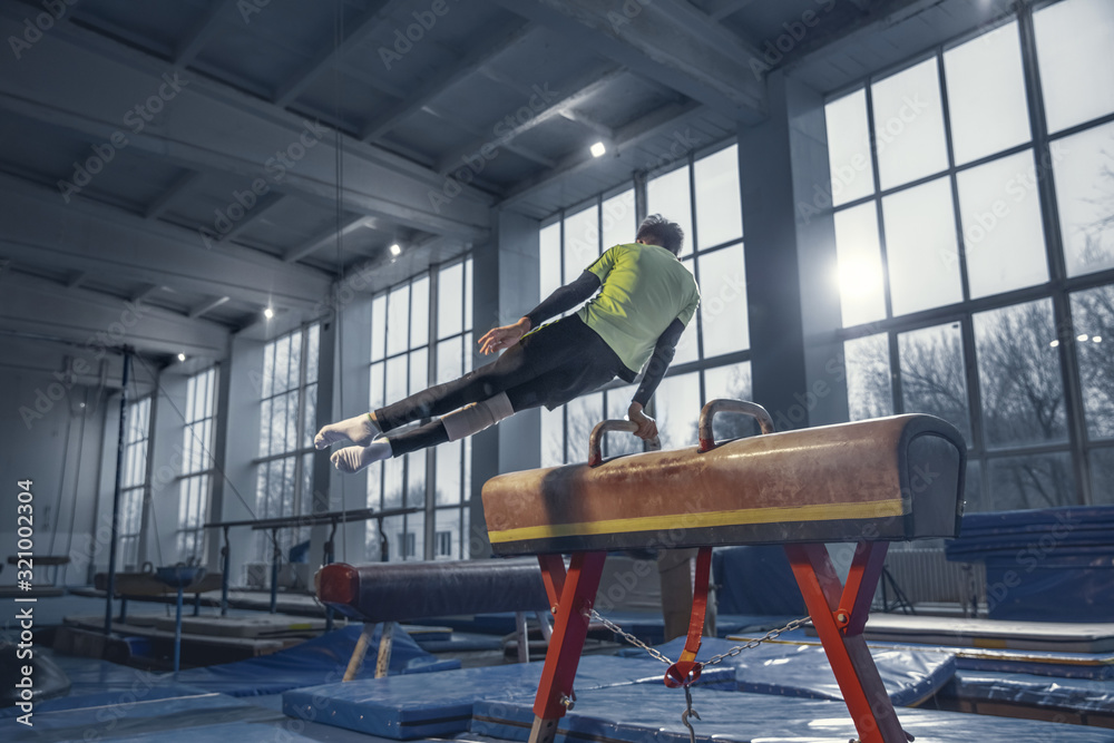 Champion. Little male gymnast training in gym, flexible and active ...
