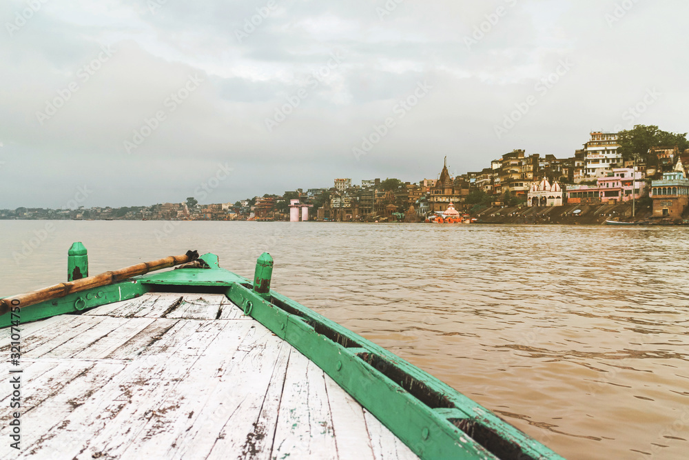 Front of the green boat floating on the Ganga River is heading to pray ...