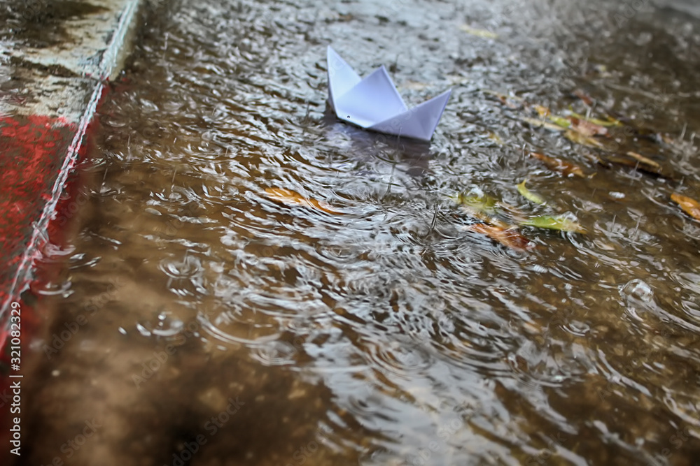 Origami Ship (Paper Boat) sails in a puddle formed after rain. Winter ...