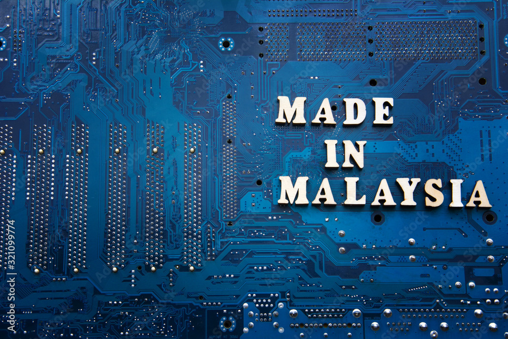 Inscription Made in Malaysia on a blue electronic printed circuit board ...
