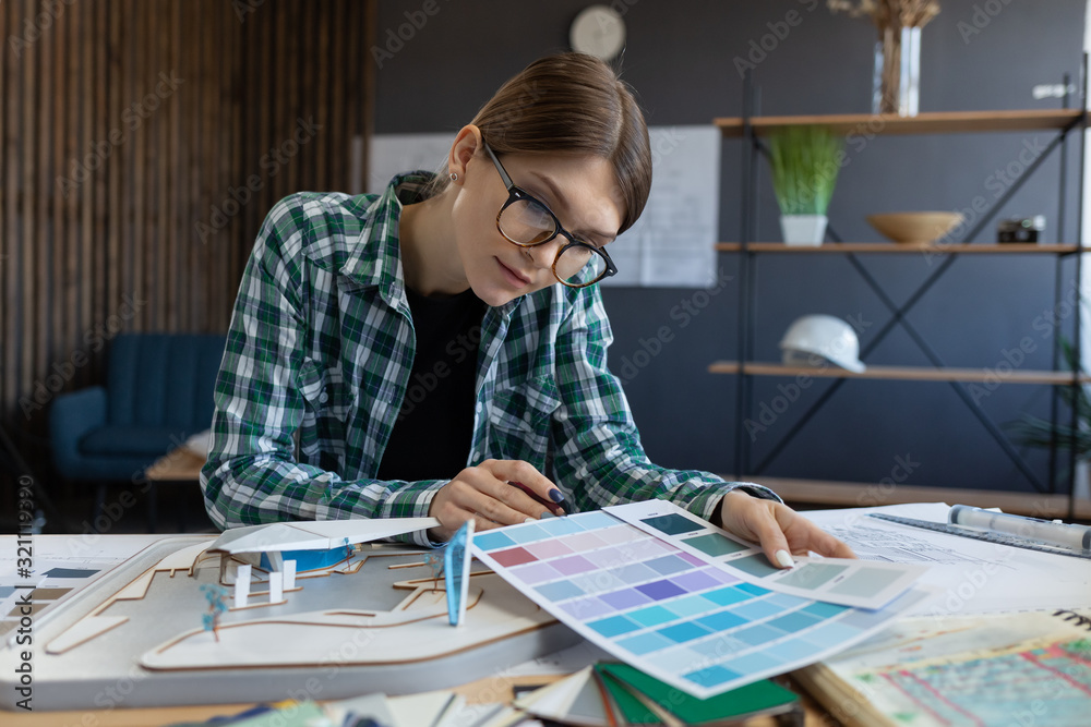 Female interior designer working in office with color palette ...