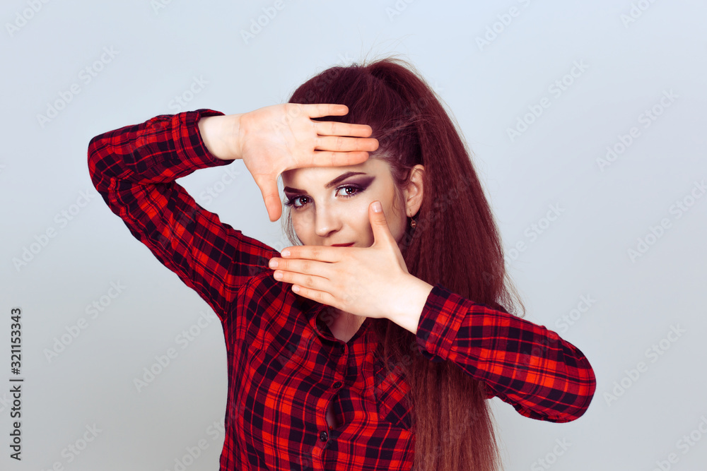 Framing. Portrait of a lovely woman smiling face framing her view her ...