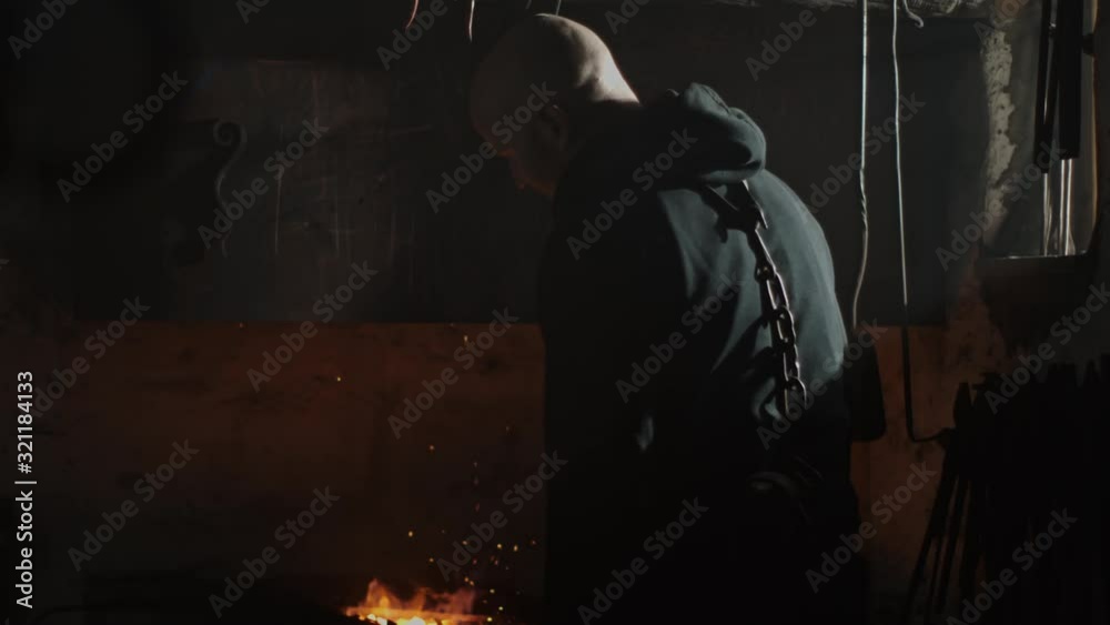 blacksmith hammering a piece of iron. Detail. hand held slow motion in ...