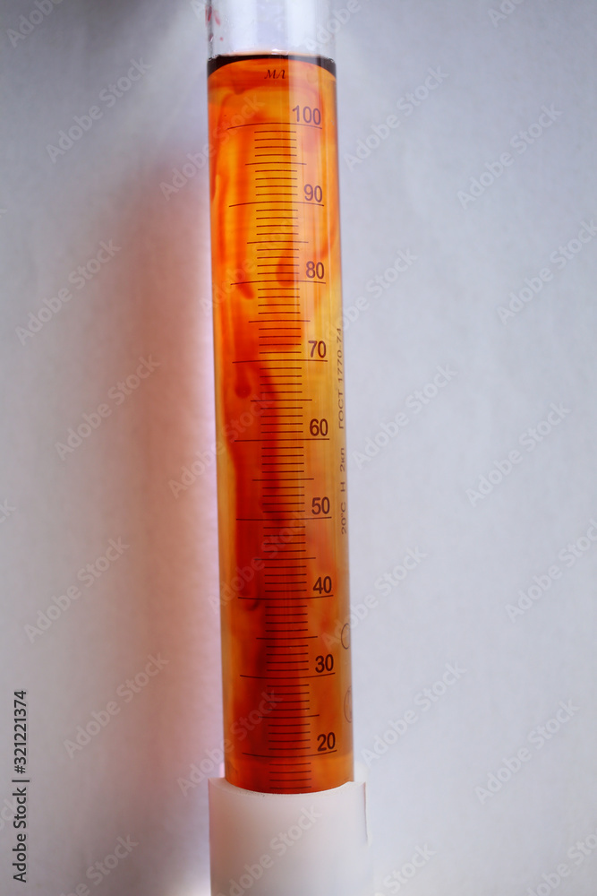 The process of dissolving a red dye in water, in a high graduated ...