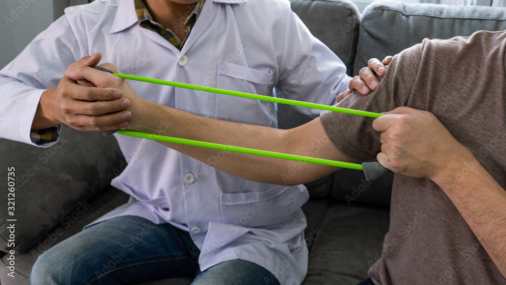 instructor assisting senior doing exercise working out in clinic ...