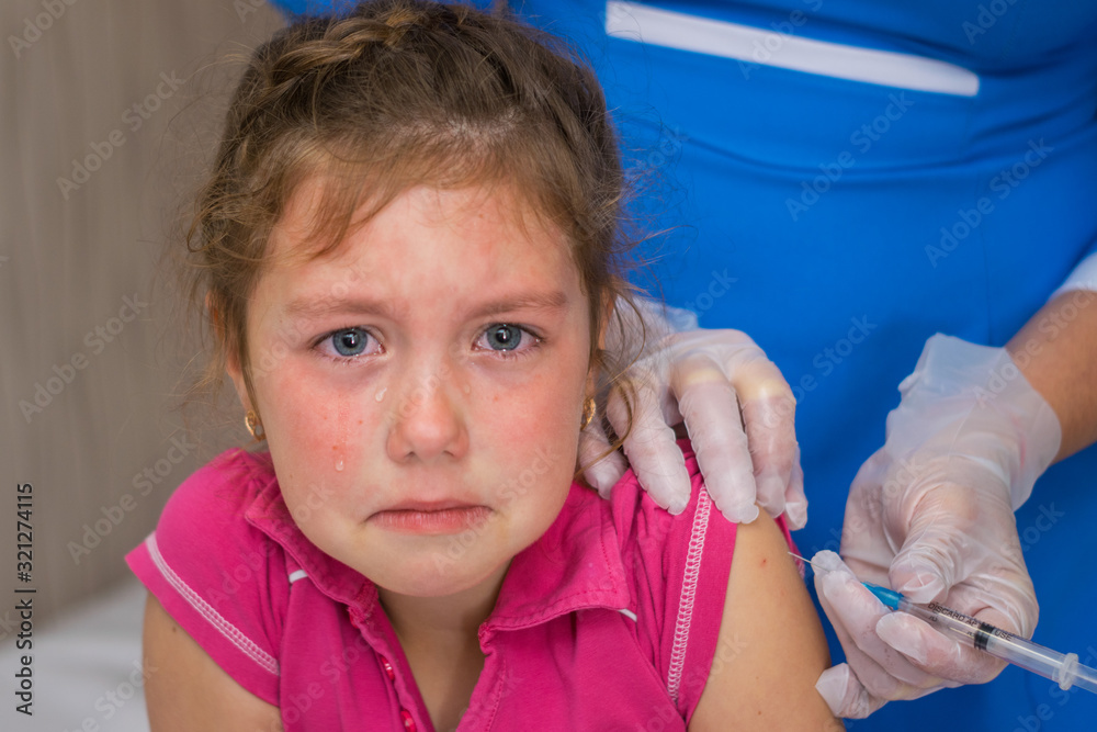 Tears on the face of a little girl due to pain from an injection ...