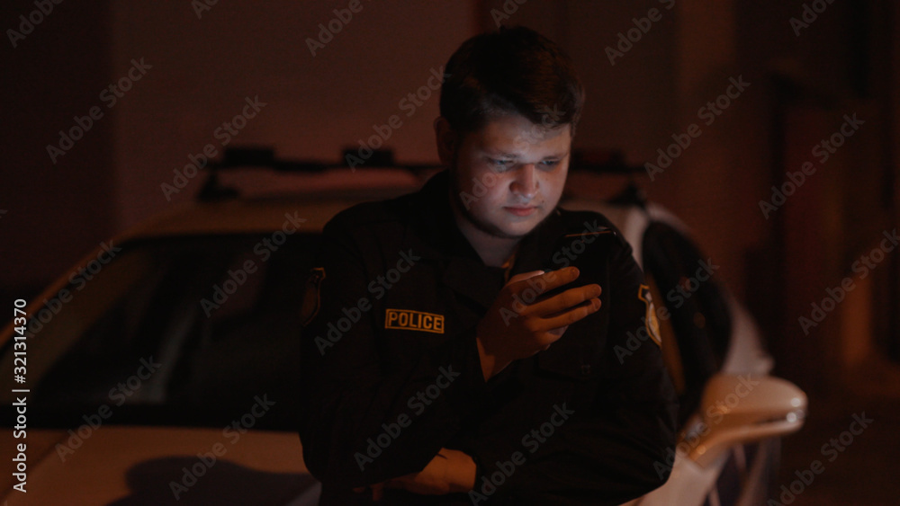 Portrait handsome young police officer chatting in social network on ...