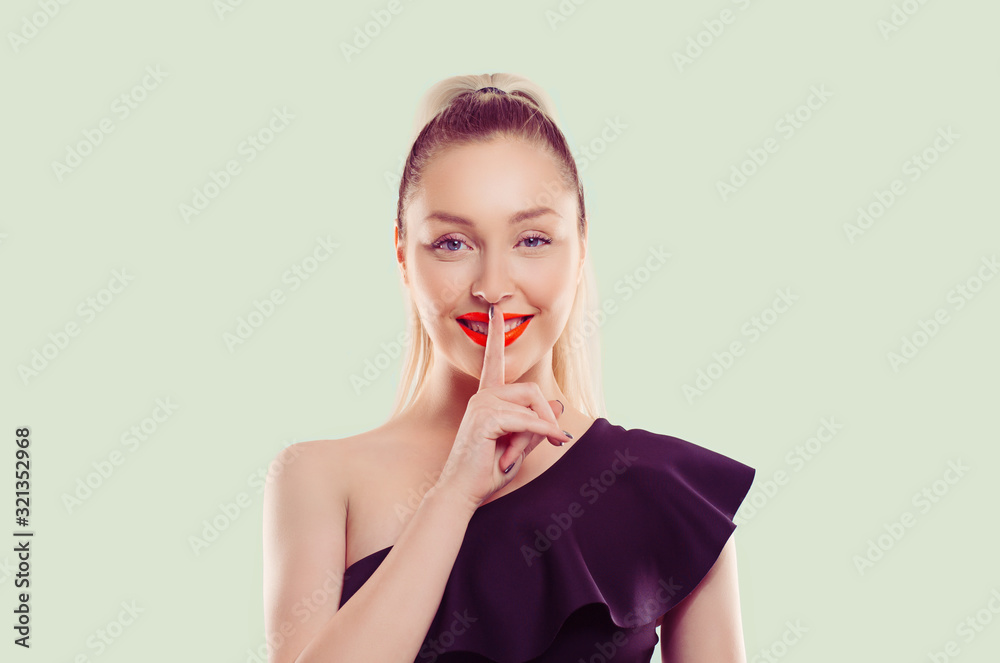 Hush. Woman smiling asking for silence or secrecy with finger on lips ...