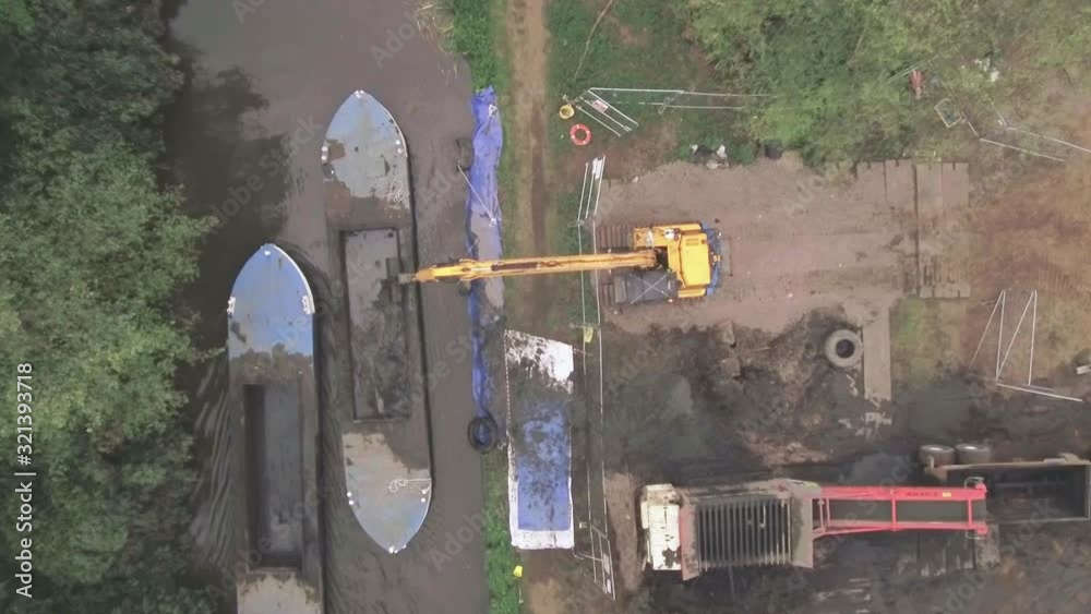 Overhead aerial of dredging operations, with two barges and yellow ...