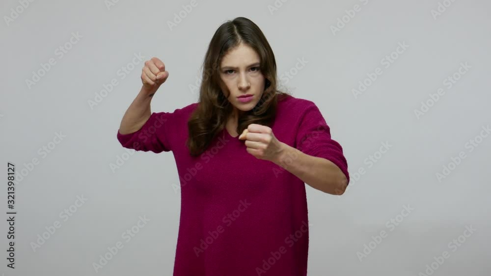 Vidéo Stock Aggressive brunette woman in pullover threatening to punch ...