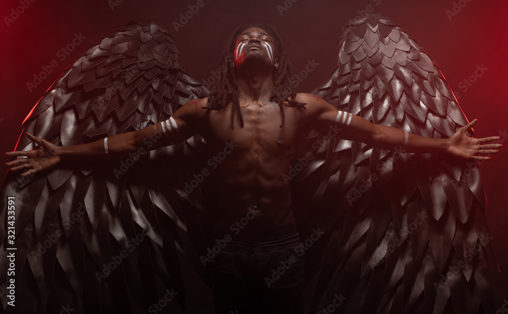 dark african angel with big black wings isolated, young serious ...