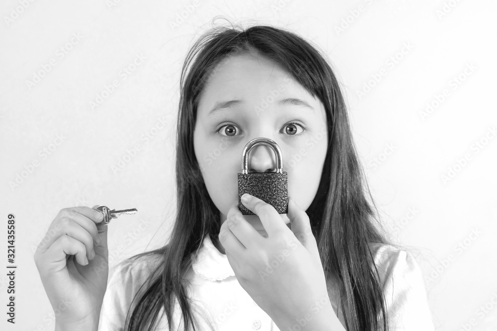 Conceptual portrait of a child keeping silence with lock over her mouth ...