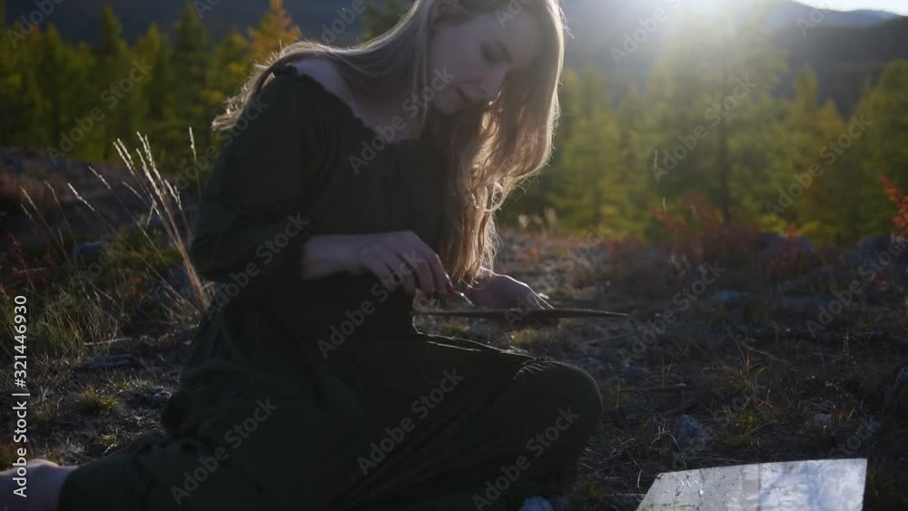 Young girl draws the summer spring landscape and sits on the ground ...