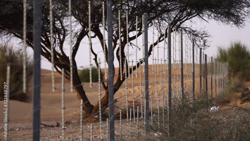 Slow Ominous Zoom Out of Fence Separating Land, Running Along Desert ...
