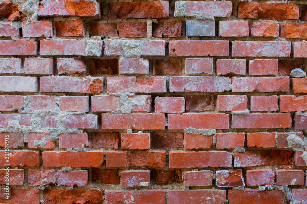 Old broken, damaged and corroded brick wall with broken bricks missing and leaving holes in the ...