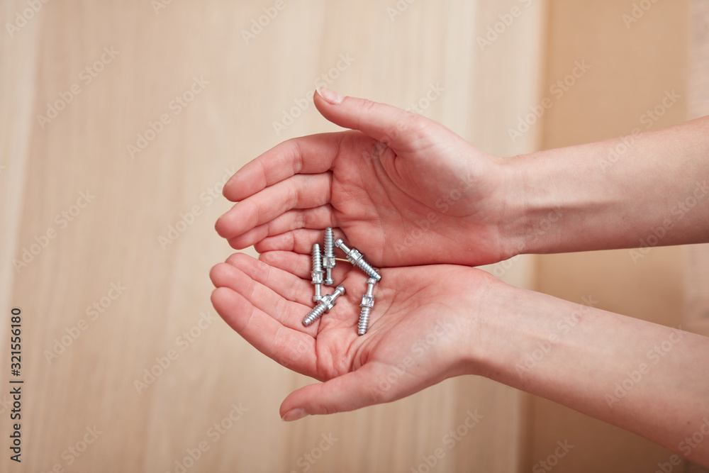 Female hands holding the screws in their hands. Concept for self ...