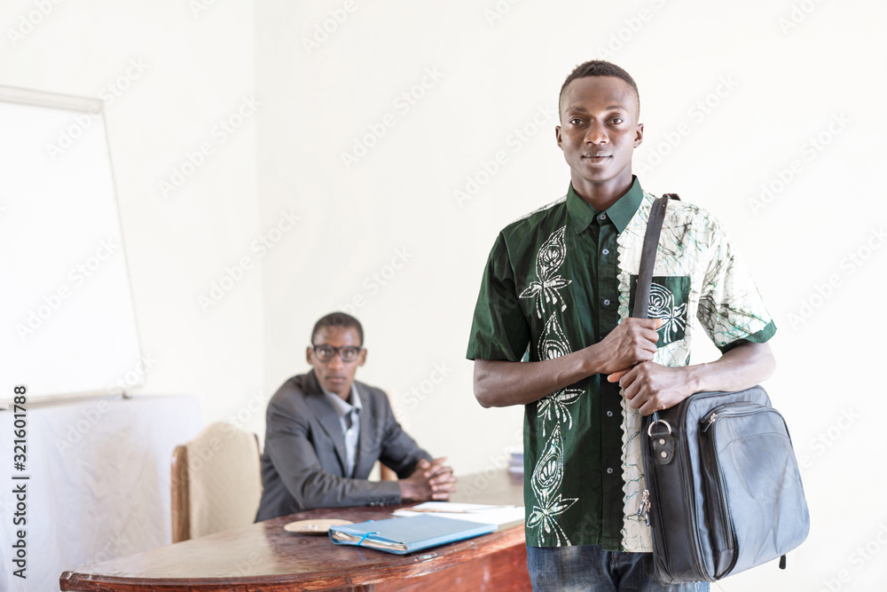 African black student posing in front of white background in an office ...
