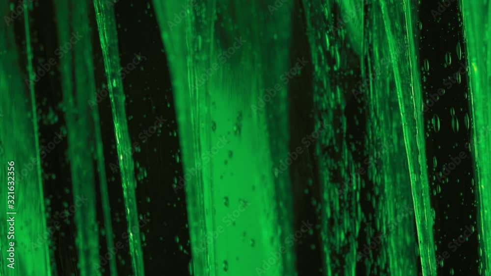 Colored sticky mucus stretches from top to bottom on the dark ...