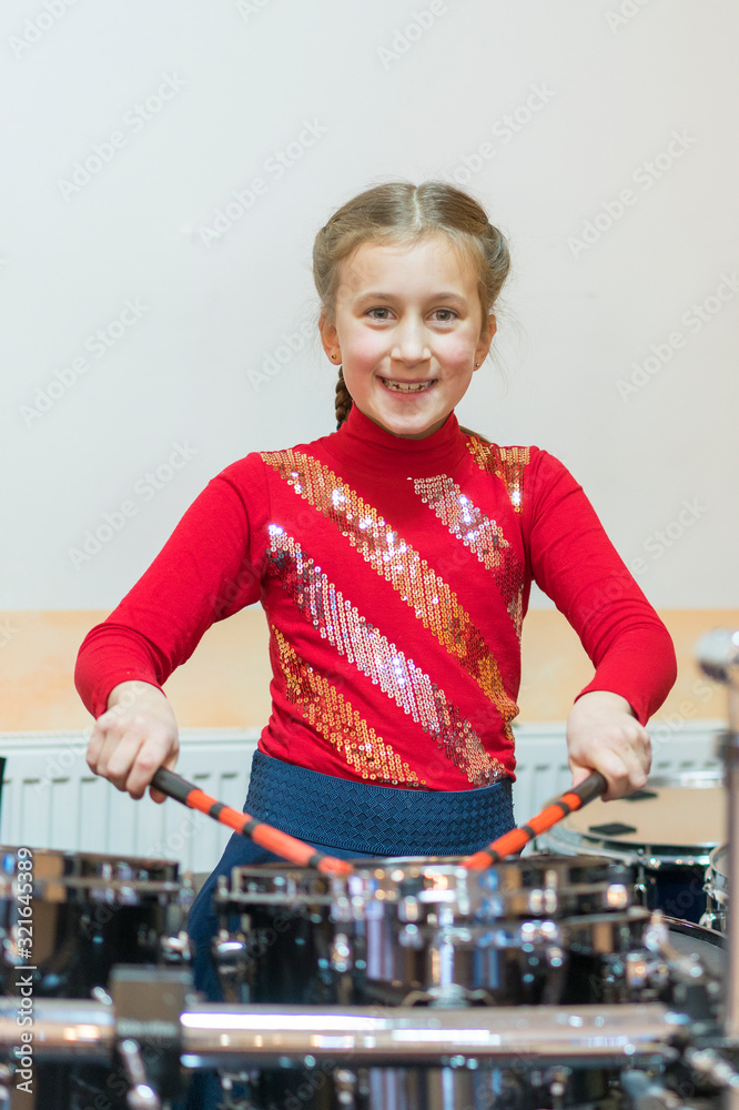 happy girl playing the drums. Teen girls are having fun playing drum ...