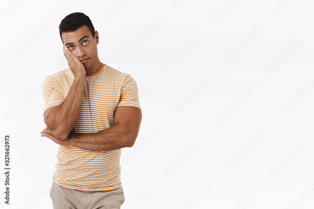 Guy looking at clock with anamused, bored face, tired sitting boring ...
