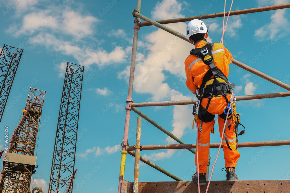 Rope access on scaffolding wearing safety harness, Construction worker ...
