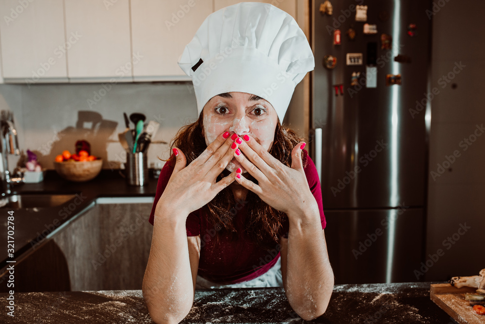 .Young woman kneading bread in her home kitchen. No culinary skills and ...